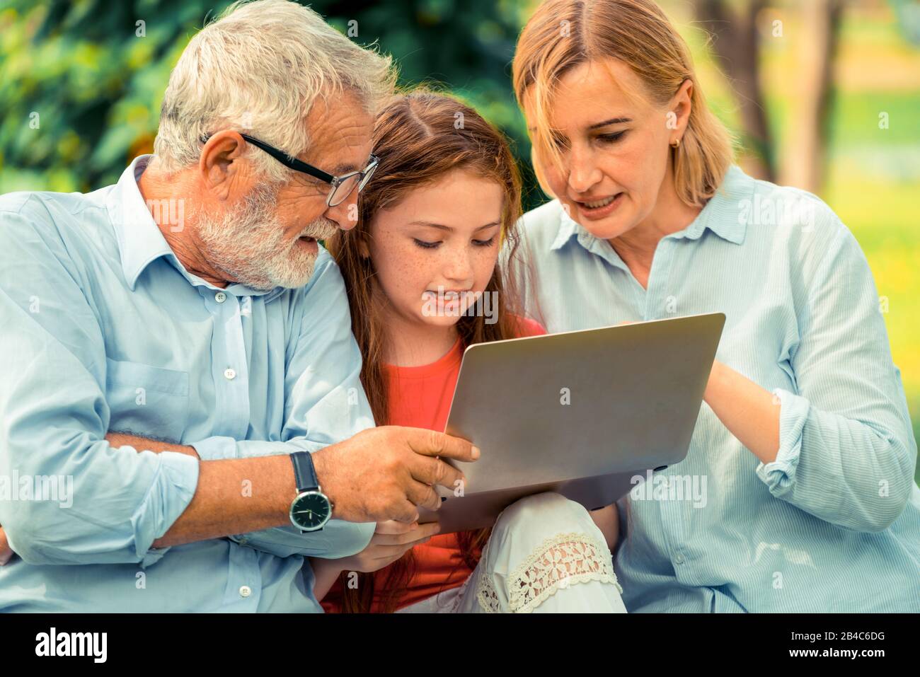 Happy family using laptop computer together in the garden park in ...