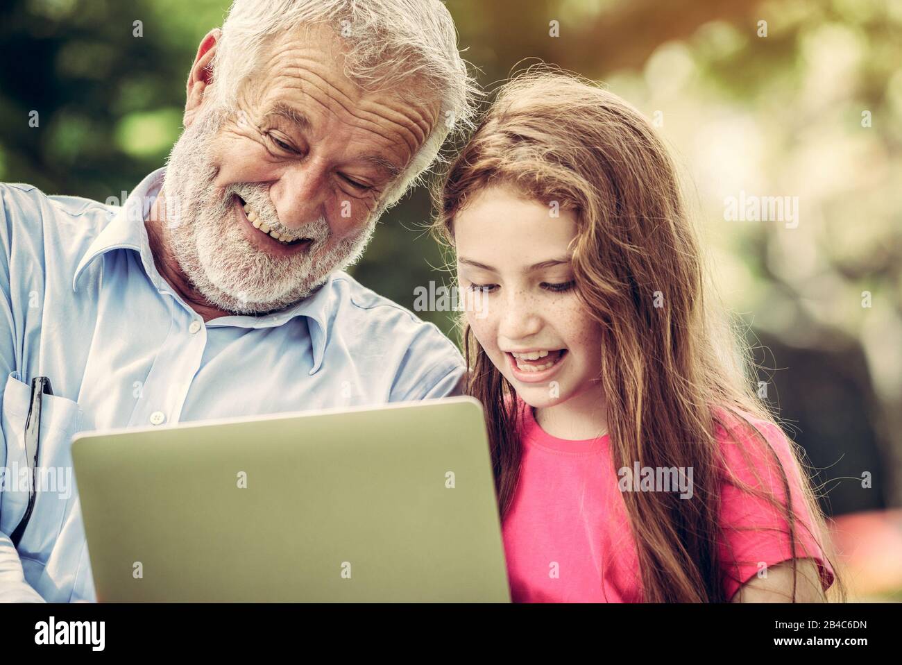 Happy family using laptop computer together in the garden park in ...