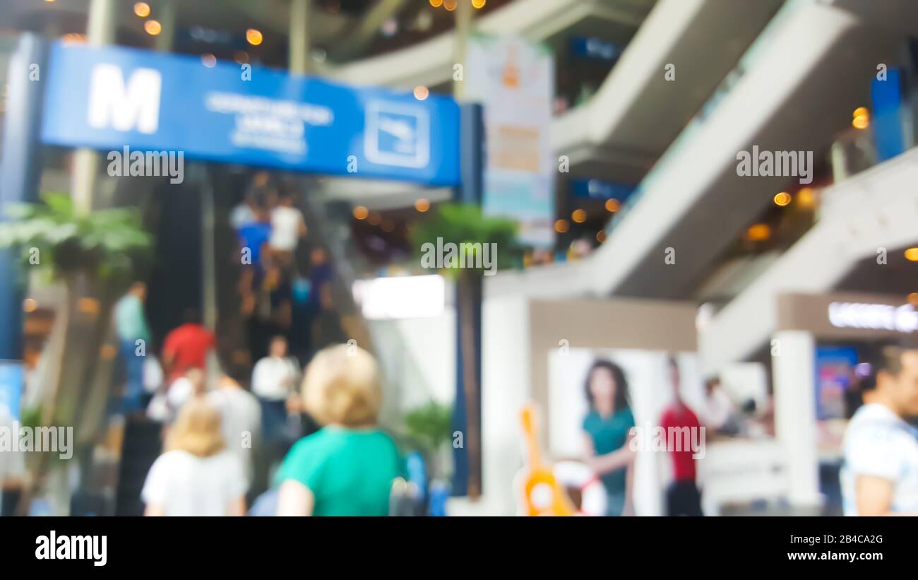 Blurred background of shopping mall central hall with people walking ...