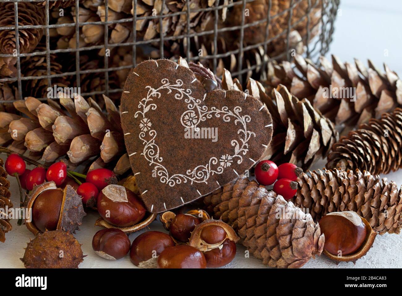 rustic autumn decoration with felt heart and pine cones and chestnuts ...