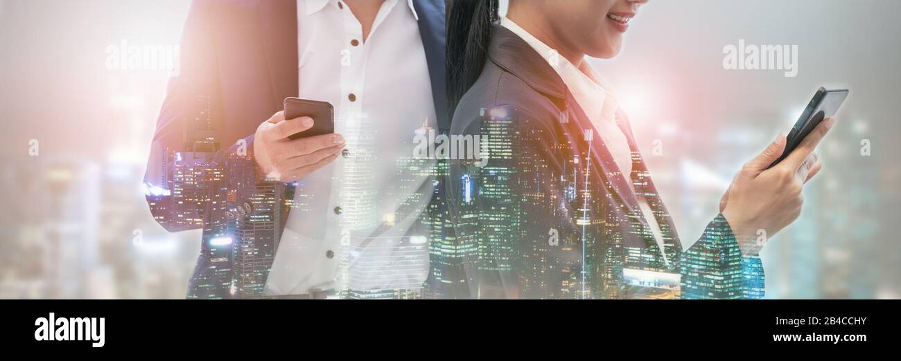 Young business people using mobile phone with modern city buildings background. Future ...