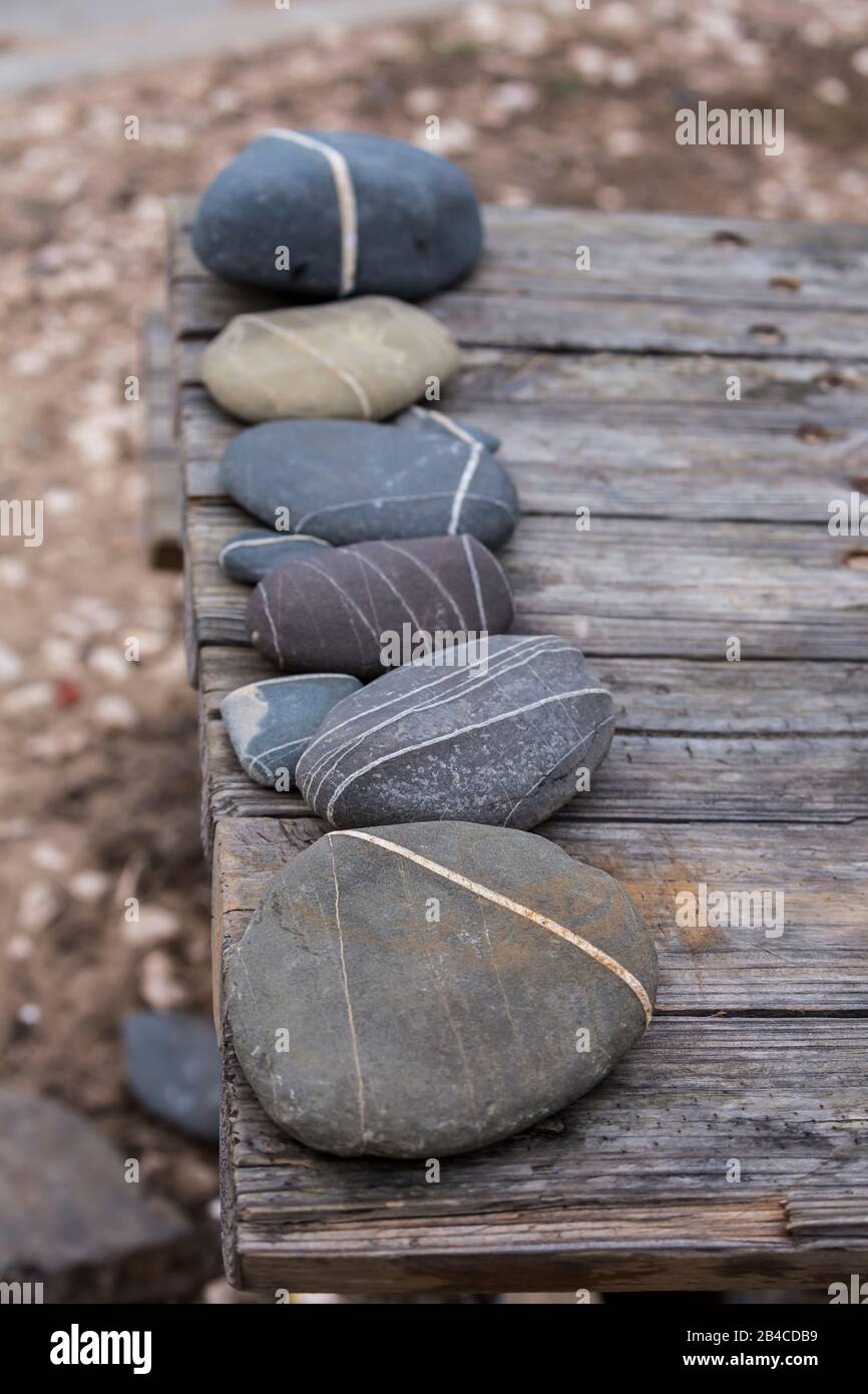 arrangement of pebble with white line on old wooden jetty at the beach ...