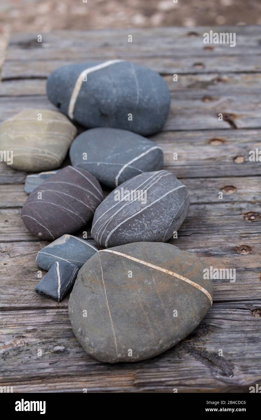 arrangement of pebble with white line on old wooden jetty at the beach ...