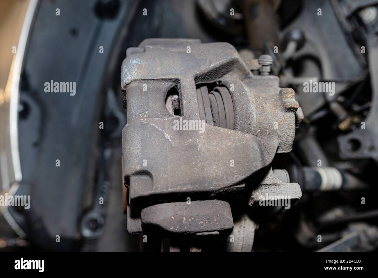 Front brake discs with brake caliper and brake pads in the car, on a ...