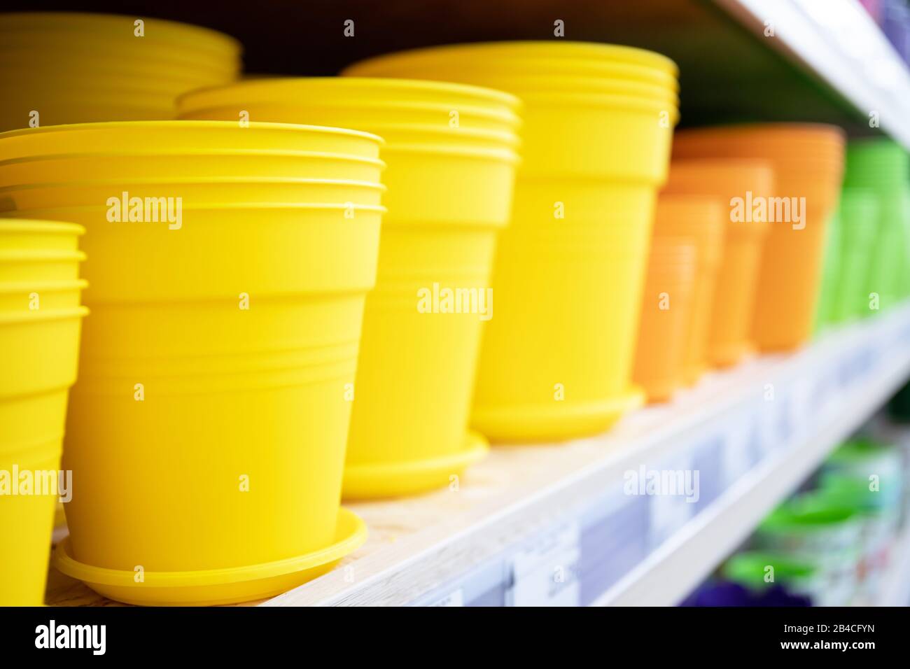 Bright yellow flower pots. Shelf in the store Stock Photo - Alamy