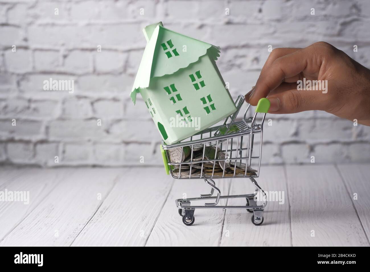 House model with shopping cart. Buying house Stock Photo - Alamy