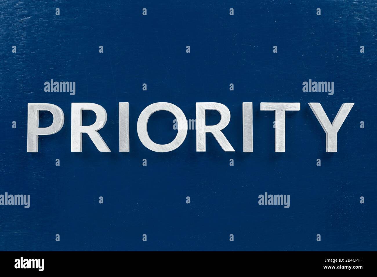 the word priority laid with silver letters on blue color surface Stock ...