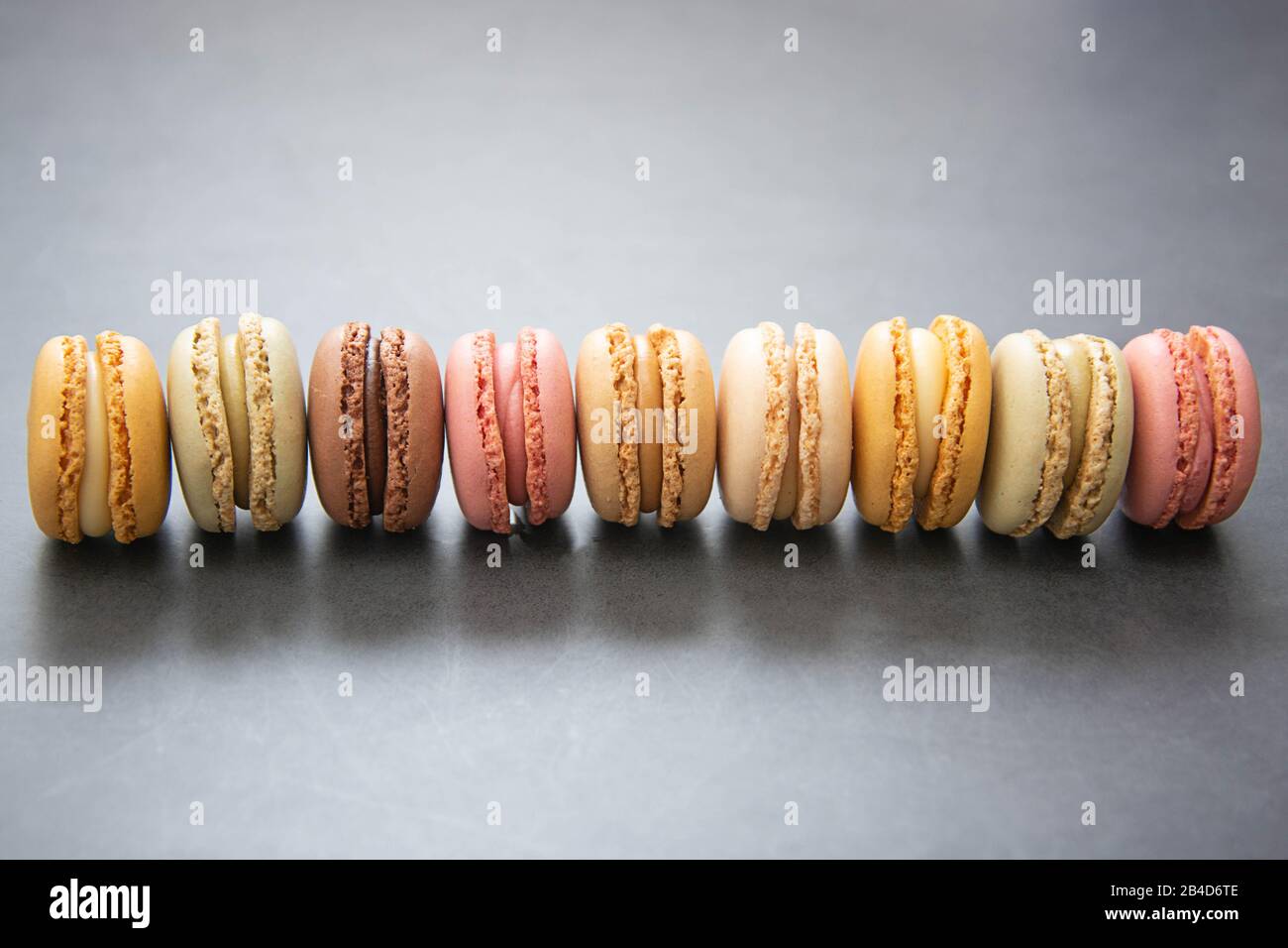Row of french colorful macaroons over dark, black background with copy ...