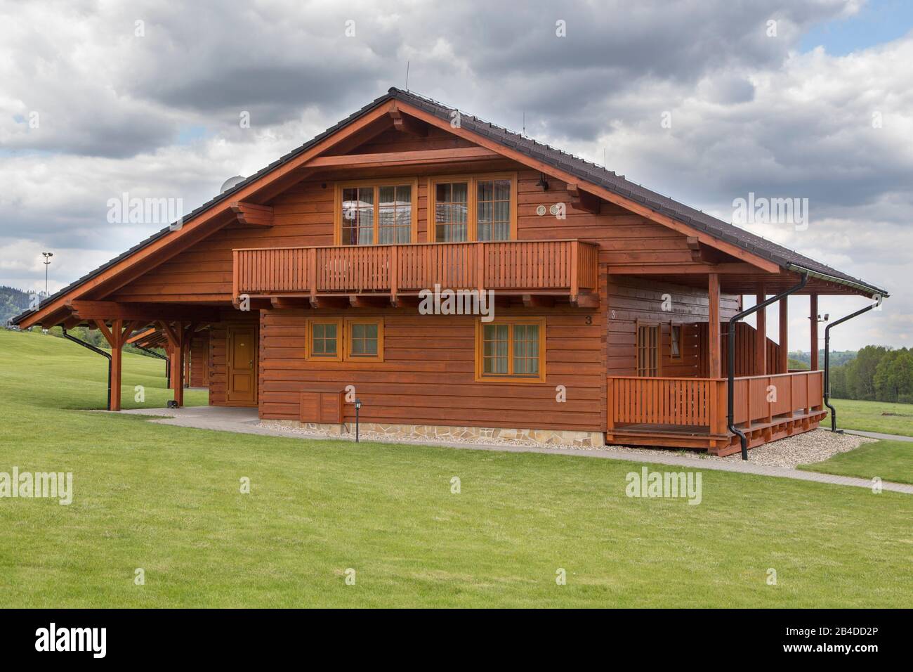 nice wooden house with lawn around Stock Photo - Alamy