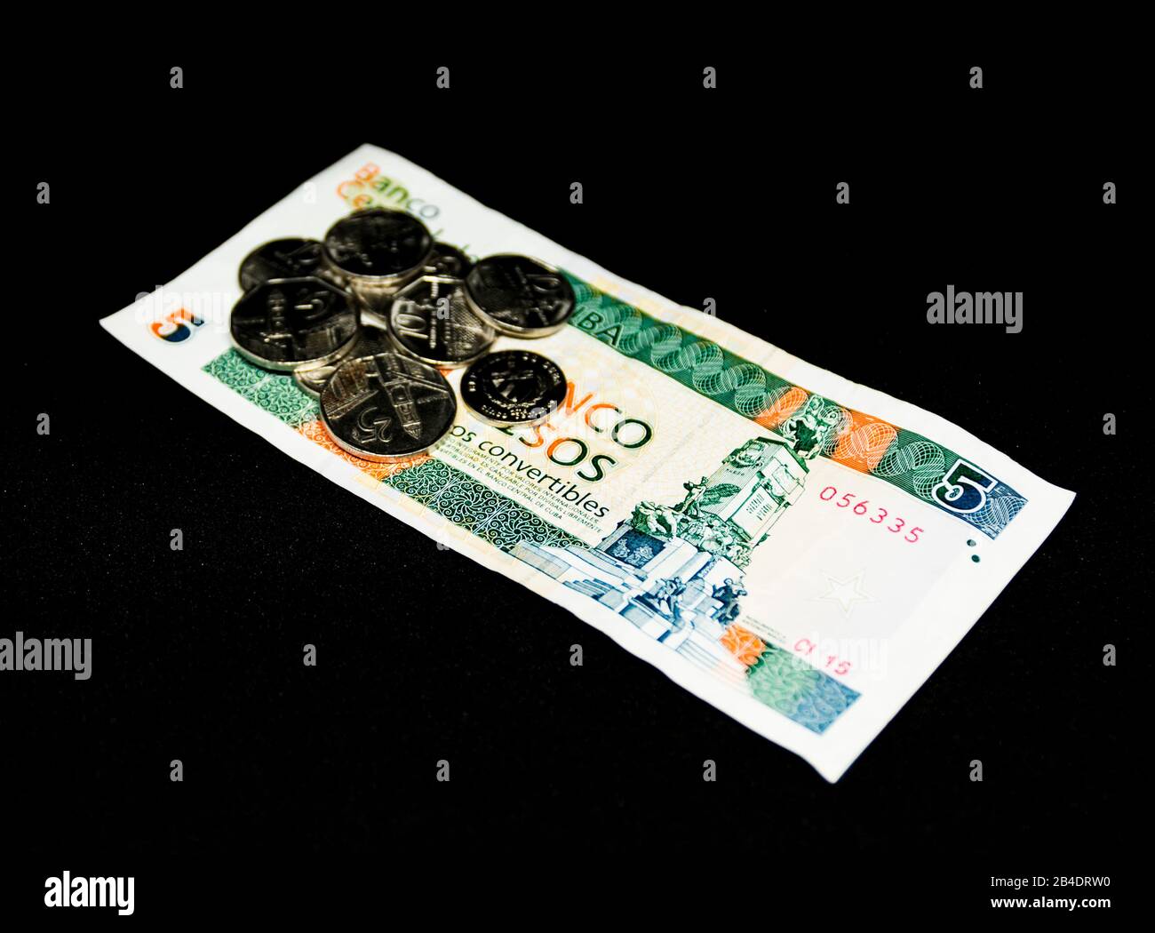 Cinco Pesos paper bill known as CUC with coins on it with a black ...