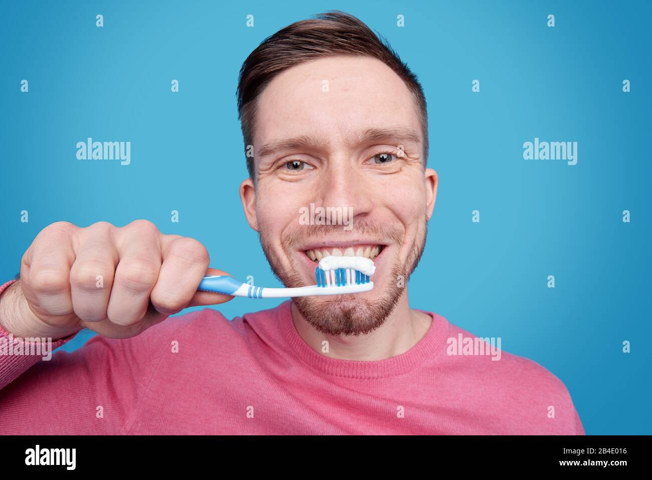 Happy young man with healthy smile going to brush his teeth while ...