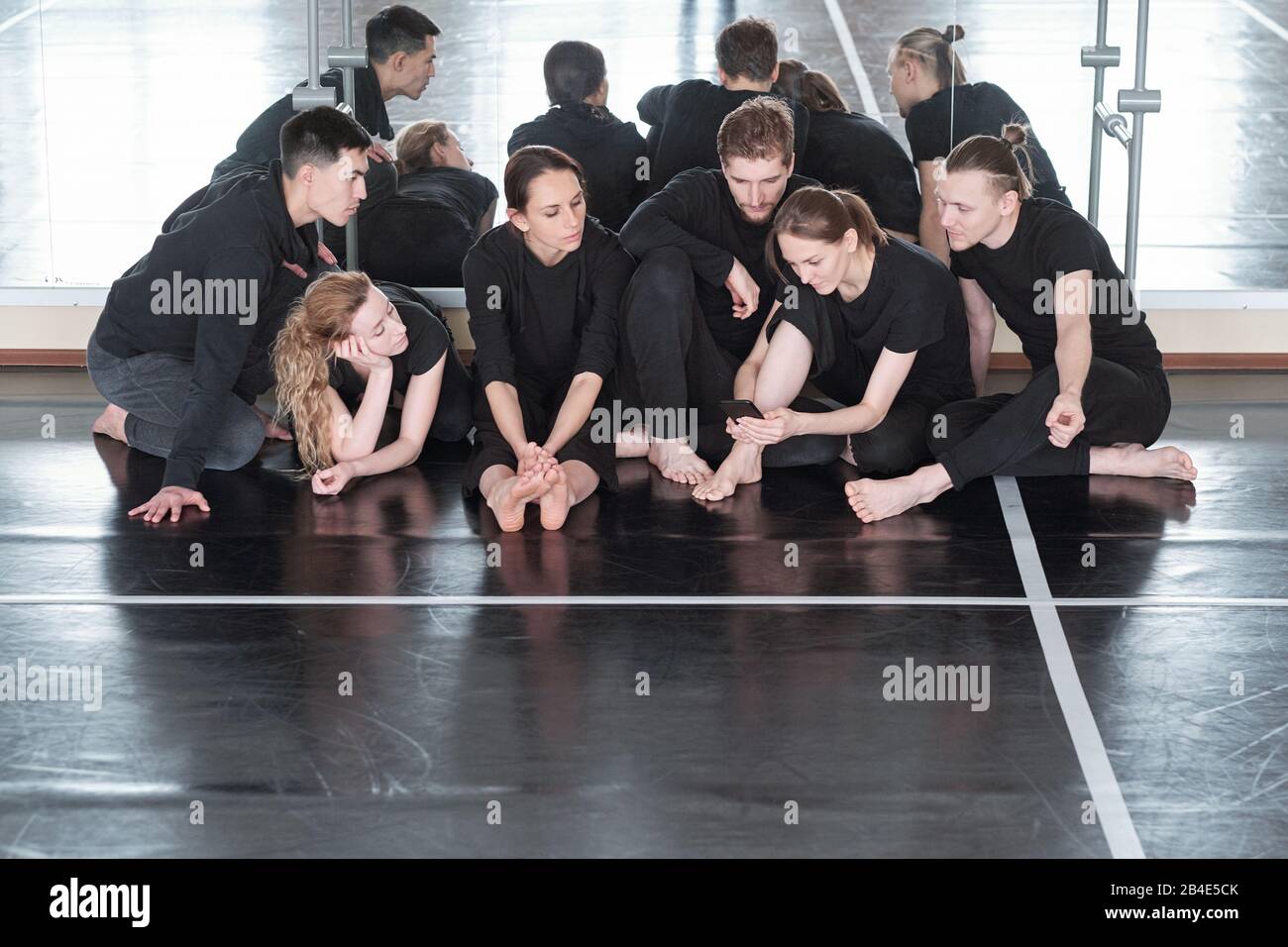 Large group of young students of modern ballet dancing course sitting ...