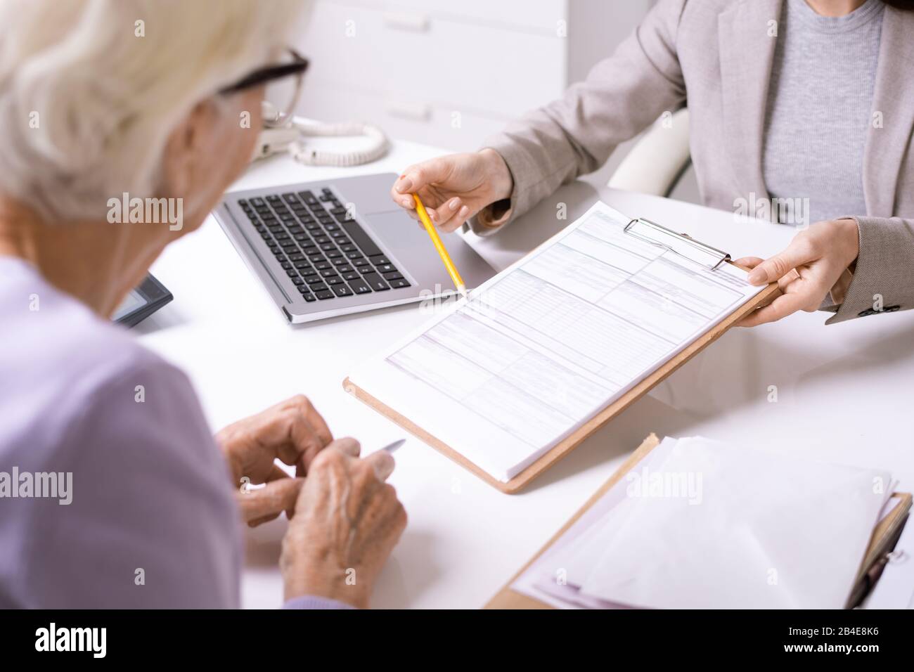Hand of young confident insurance agent with pencil pointing at form ...