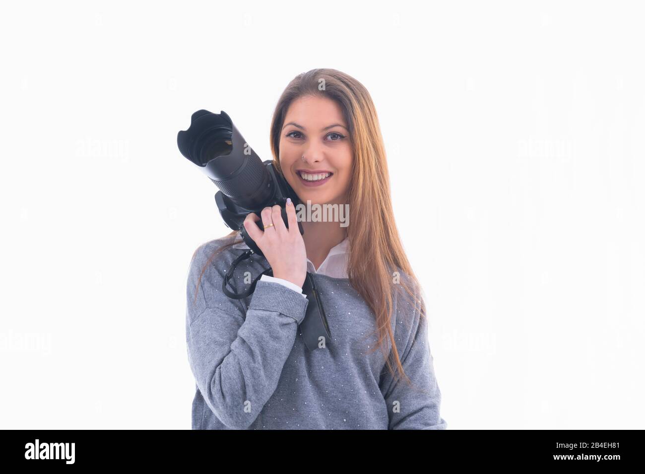 Smiling photographer holding a camera next to her face Stock Photo - Alamy