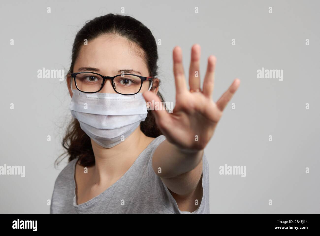 a girl in a mask shows a stop gesture fearing for the health of people ...