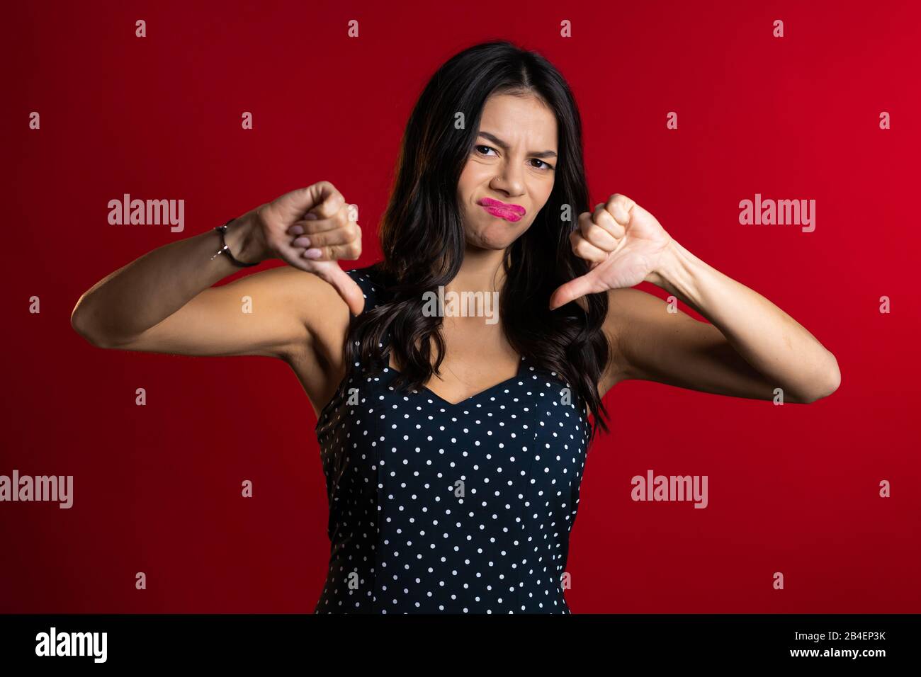 Young pretty woman standing on red studio background expressing ...
