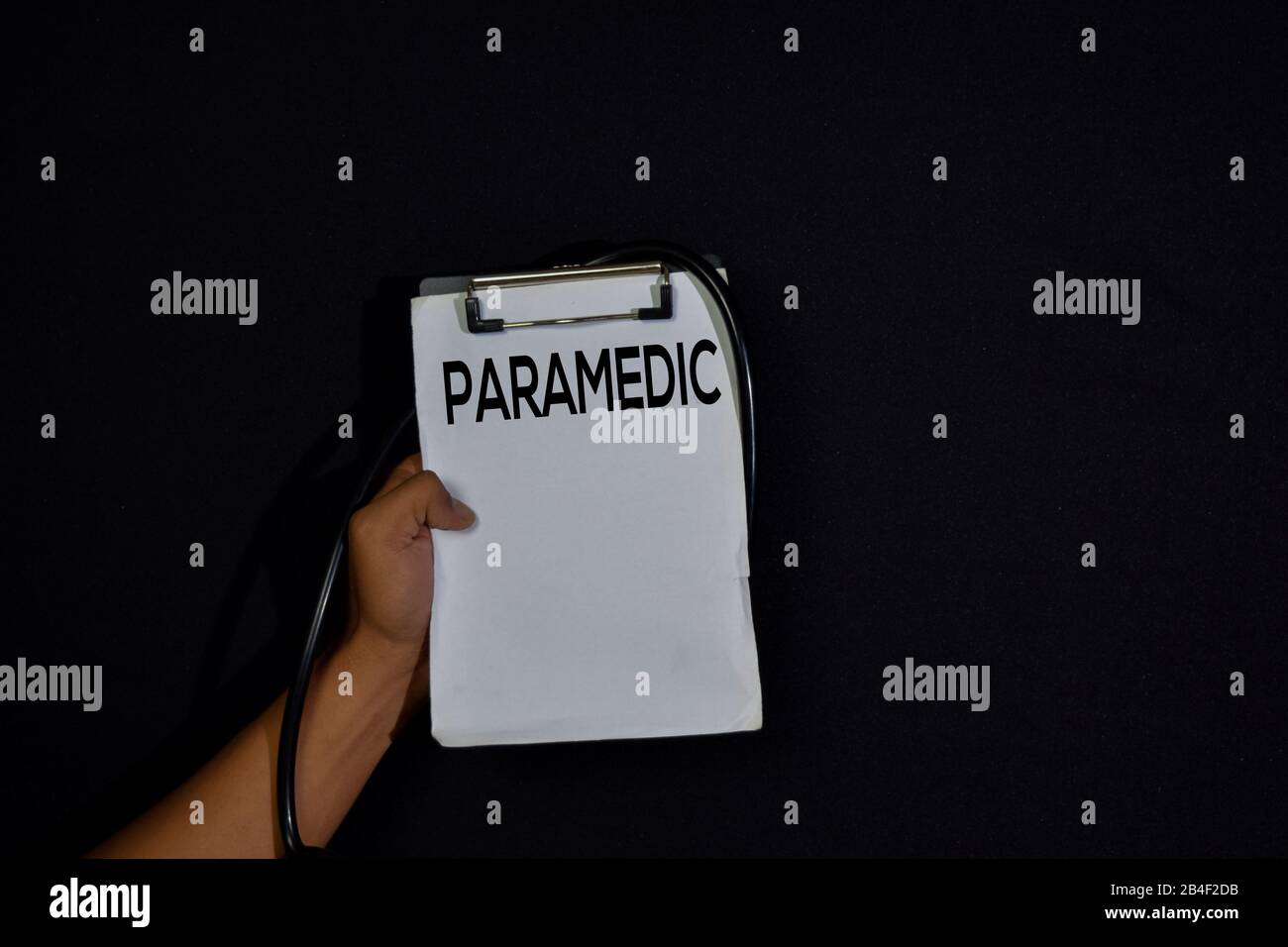 Paramedic write on paperwork isolated on dark black background ...