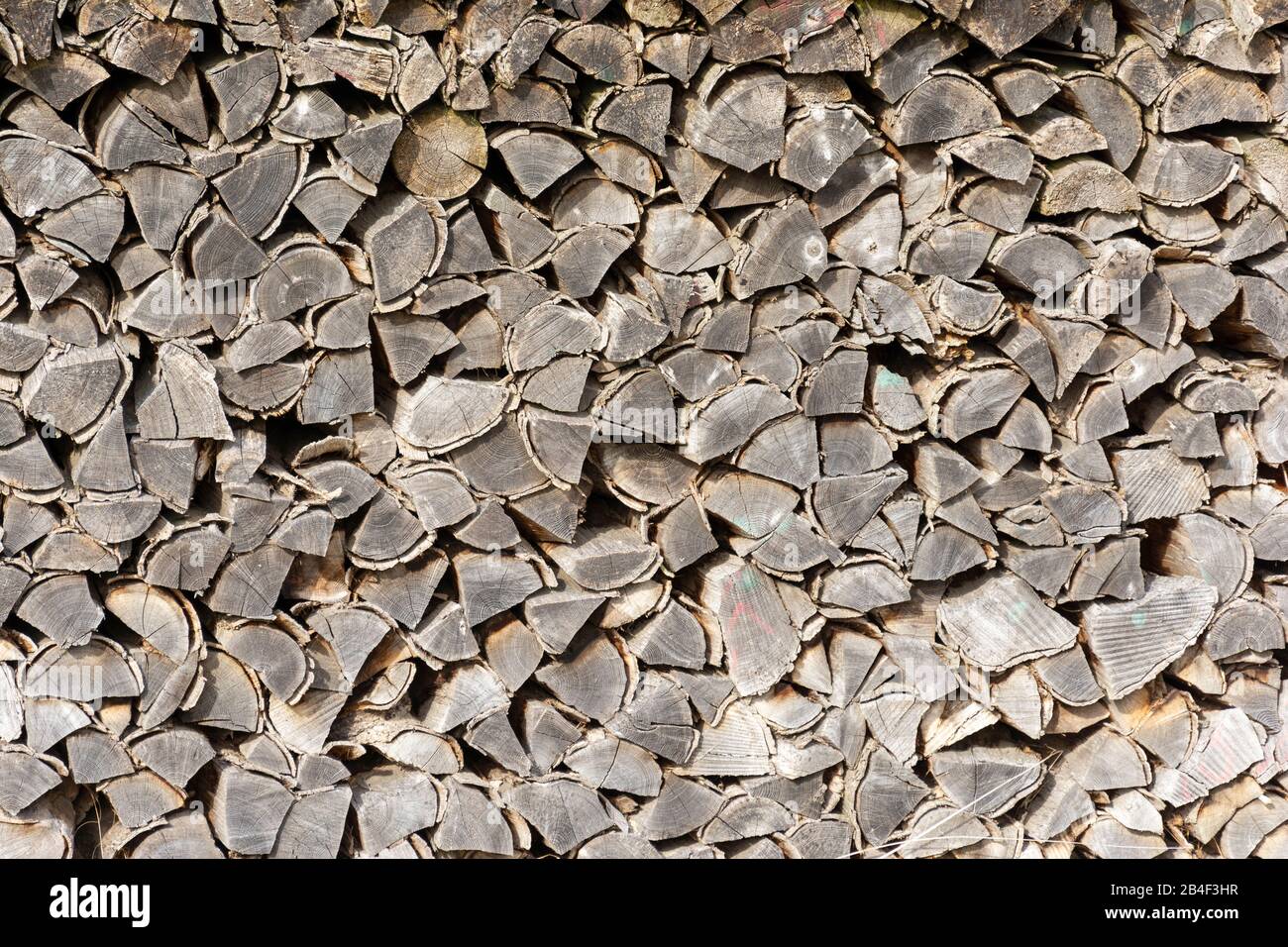 Firewood warehouse with gray logs Stock Photo - Alamy