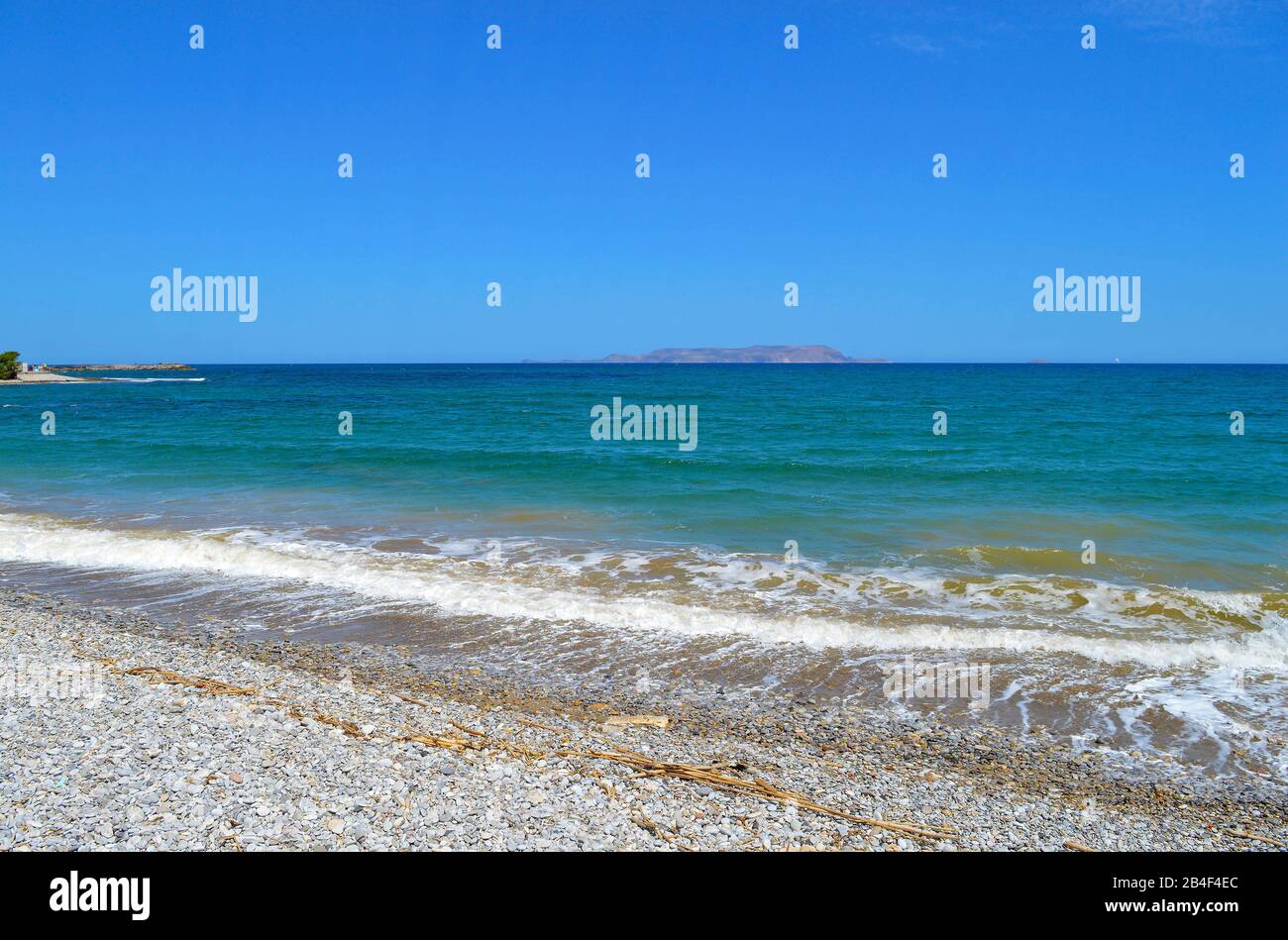 Kato Gouves pebble beach in Crete with the island of Dia on the horizon ...