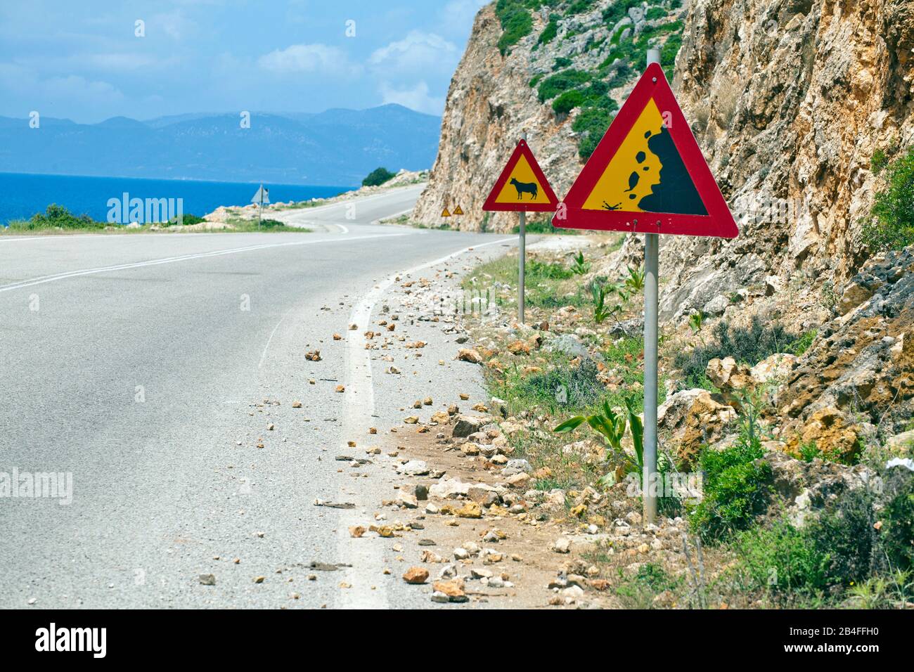 typical warning signs against stone hits and cattle on a country road ...