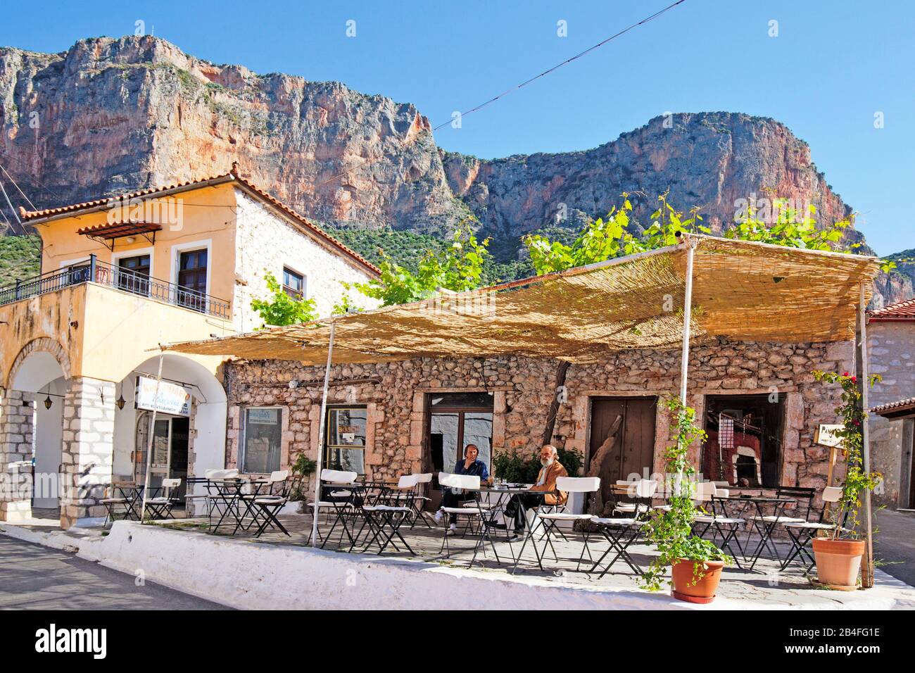 Tavern in Leonídion in front of the famous rock walls of Parnon ...