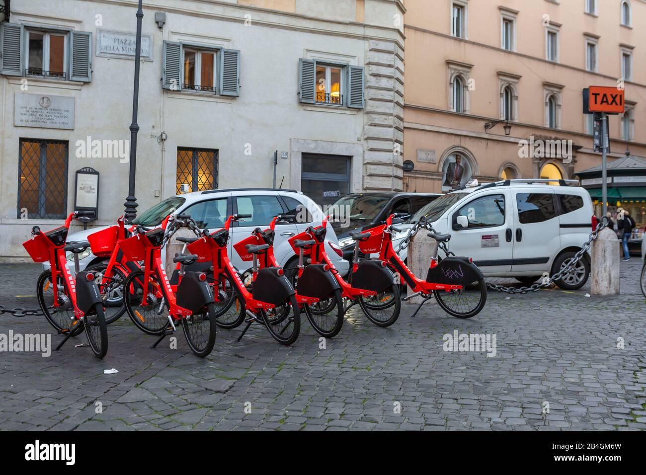 A row of Uber Jump electric bikes lined up alongside taxis waiting for ...