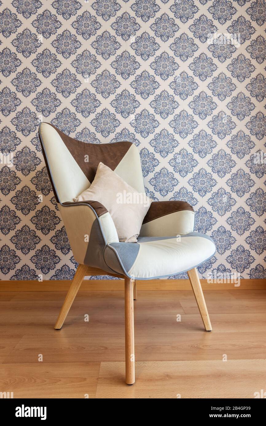 Decorative chair on the background of the wall with paper wallpaper ...