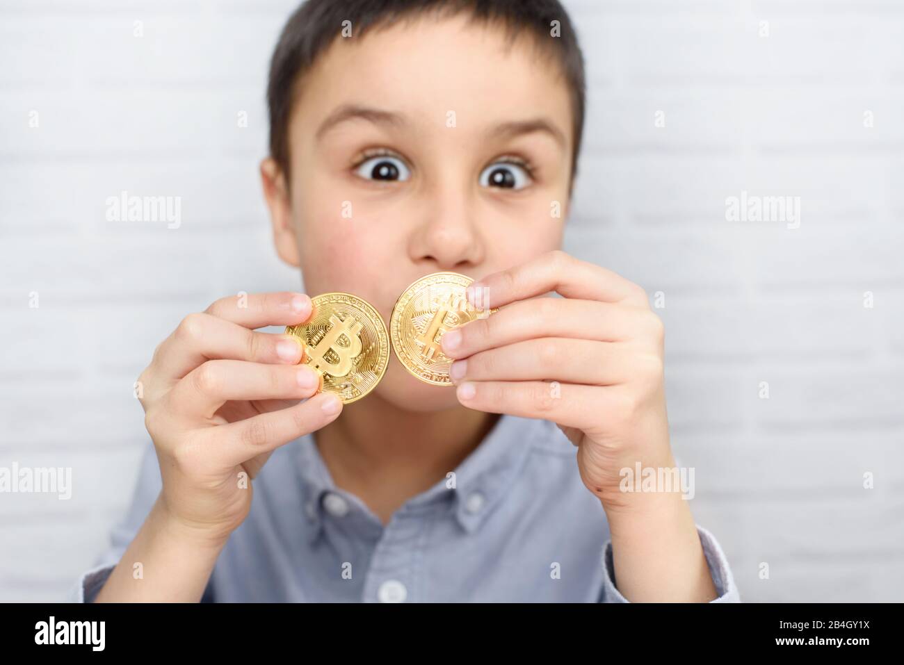 Little boy holding Bitcoin coin. Coin Focus. Child holding ...