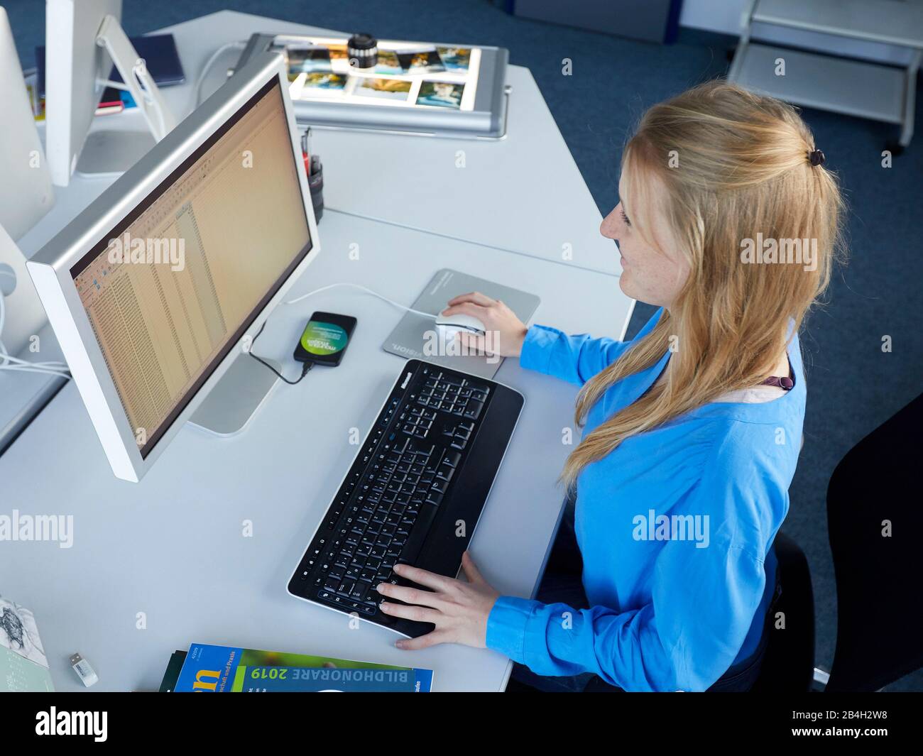 Young woman working at desk with computer Stock Photo - Alamy