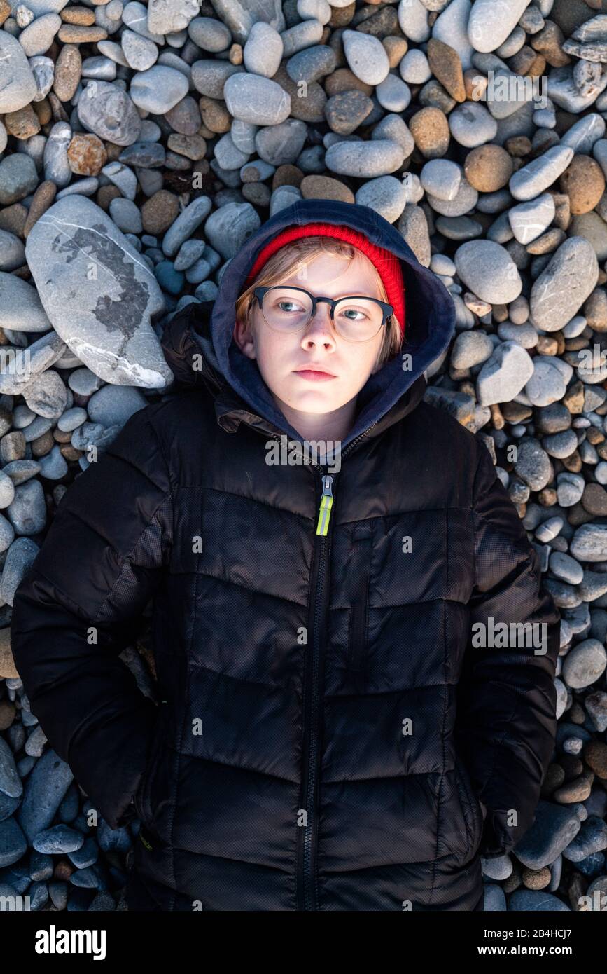 Top down view of tween boy lying on gray and brown stones Stock Photo ...