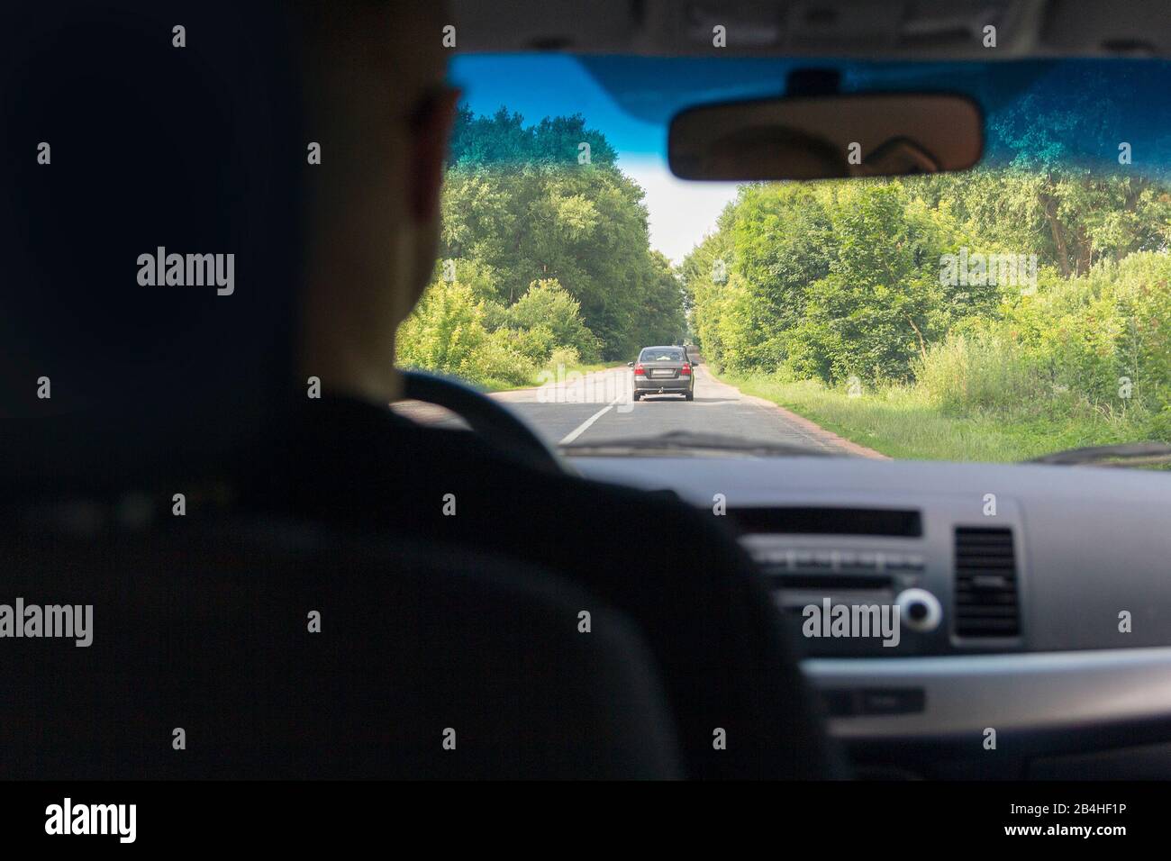 Rear view and rear view of the driver behind the wheel of the car and ...