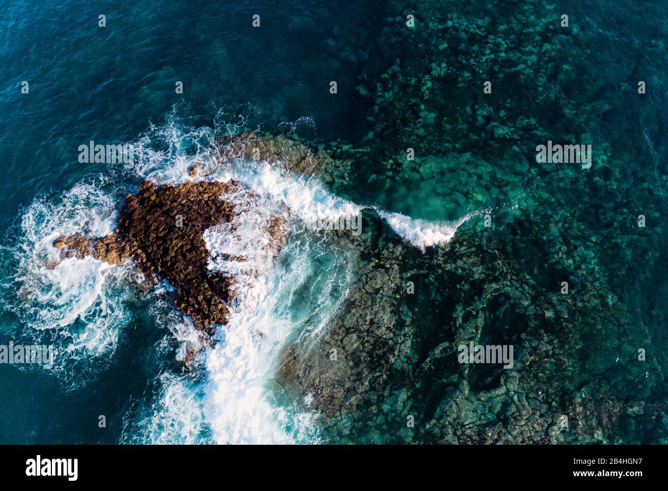 Aerial view of a wave breaking over a sharp lava reef in Tenerife Stock ...