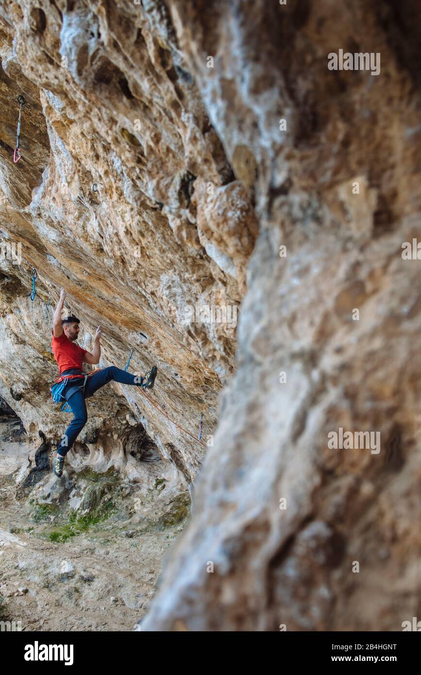 Climber begining a hard route in a sport climbing cave Stock Photo - Alamy