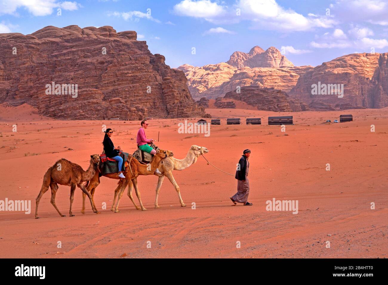 Landscape of rock and sand desert Wadi Rum with tourists on camels east ...