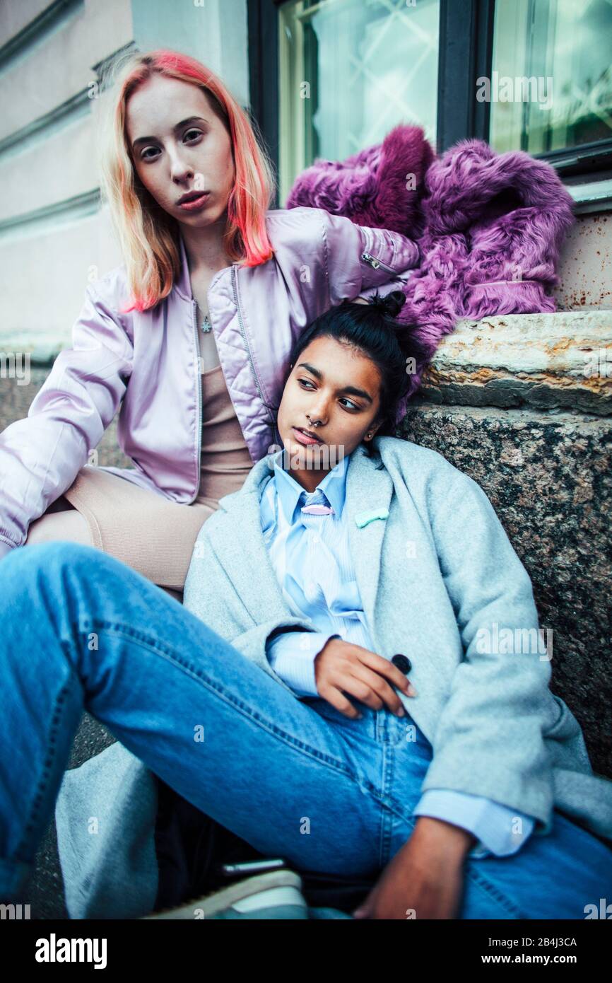 Two teenage girls infront of university building smiling, having fun ...