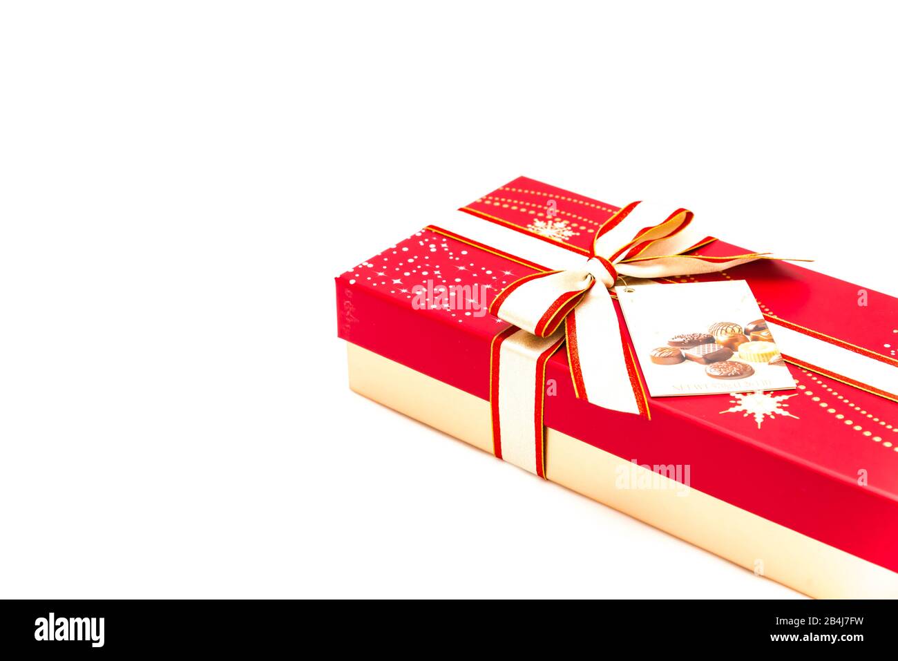 Red chocolate box with tag label and red yellow bow ribbon isolated on ...