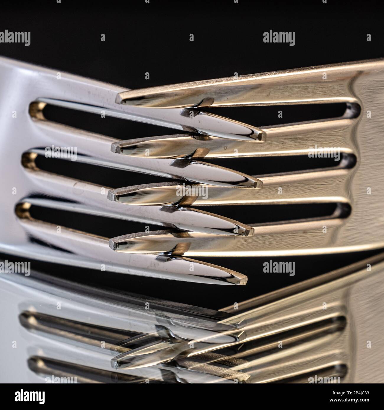 A fork detail in a black background and reflection Stock Photo - Alamy
