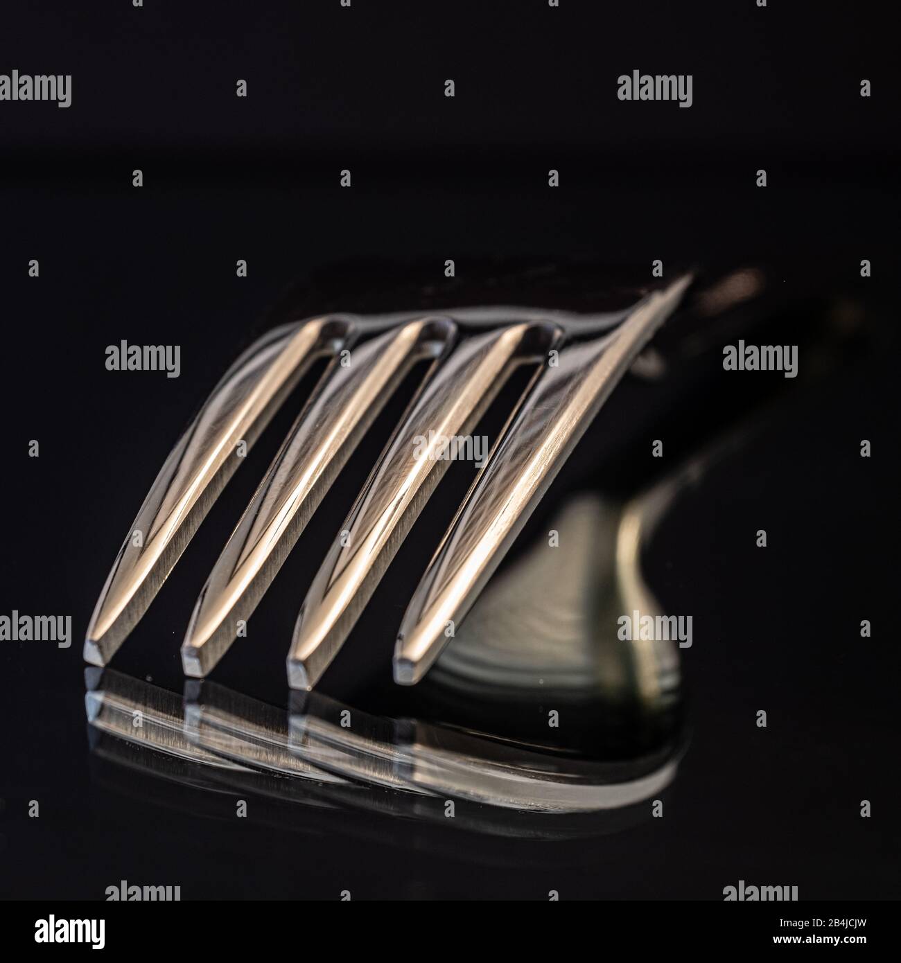 A fork detail in a black background and reflection Stock Photo - Alamy