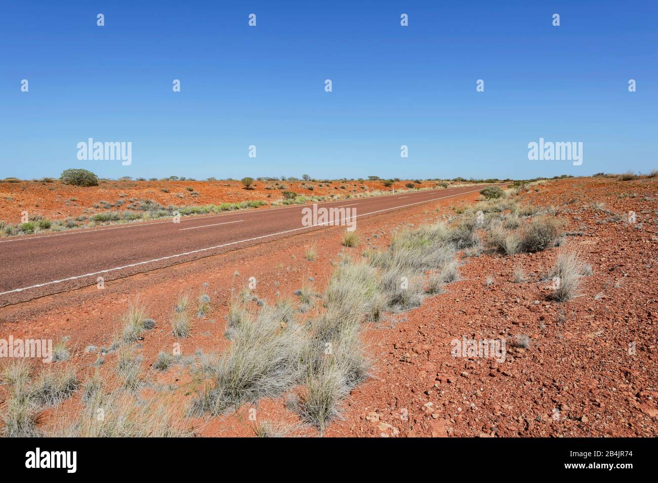 Outback road built with ochre bitumen in the Red Centre, Northern ...