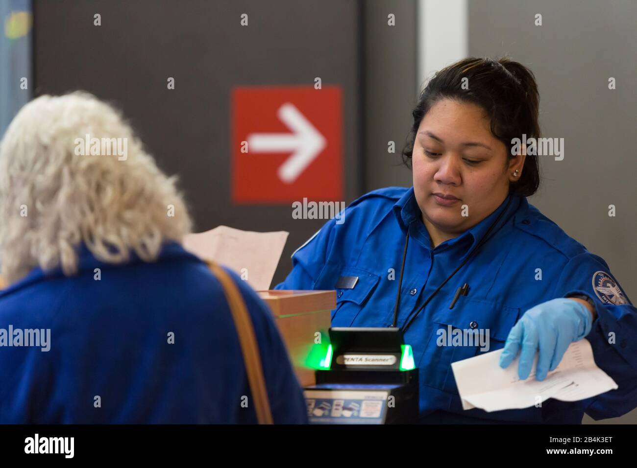 A TSA agent screens a passenger at a security checkpoint in the Central ...