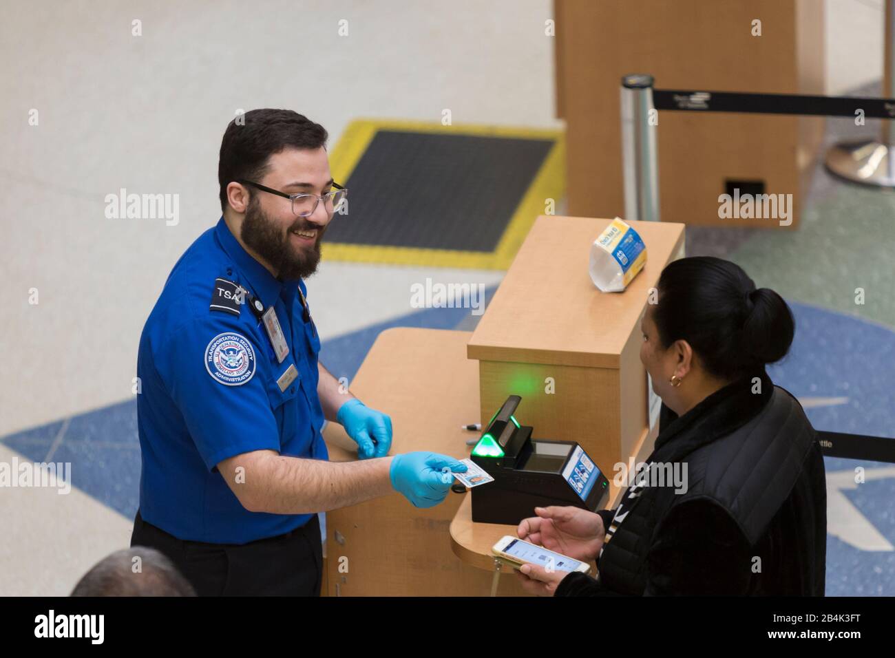A TSA agent screens a passenger at a security checkpoint in the Central ...