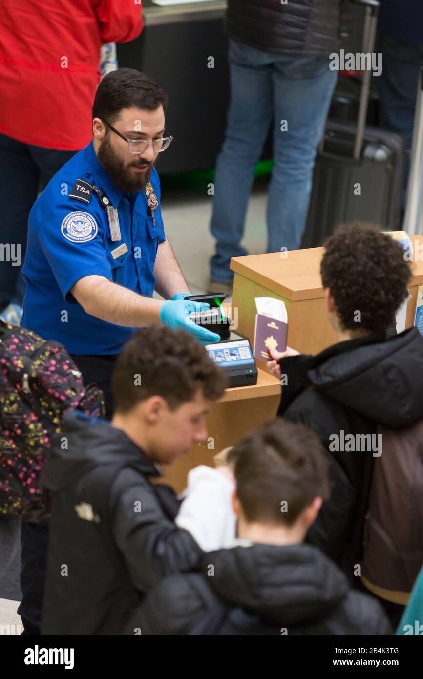 A TSA agent screens a passenger at a security checkpoint in the Central ...