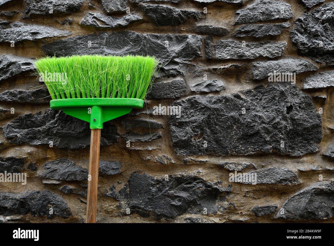 Neon green broom leaning against house wall hi-res stock photography ...