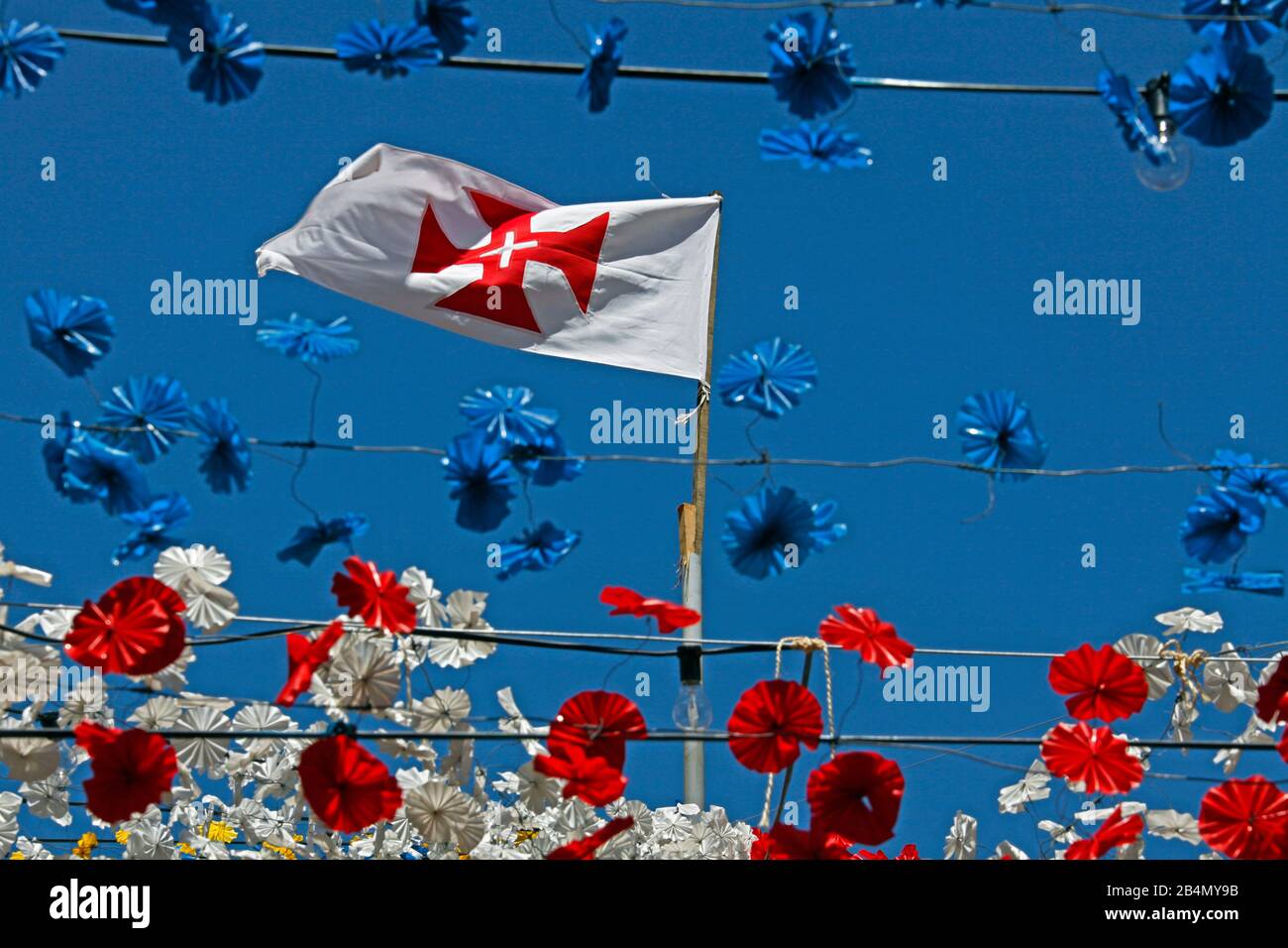 Festively decorated old town, flag with the Cross of the Order of ...