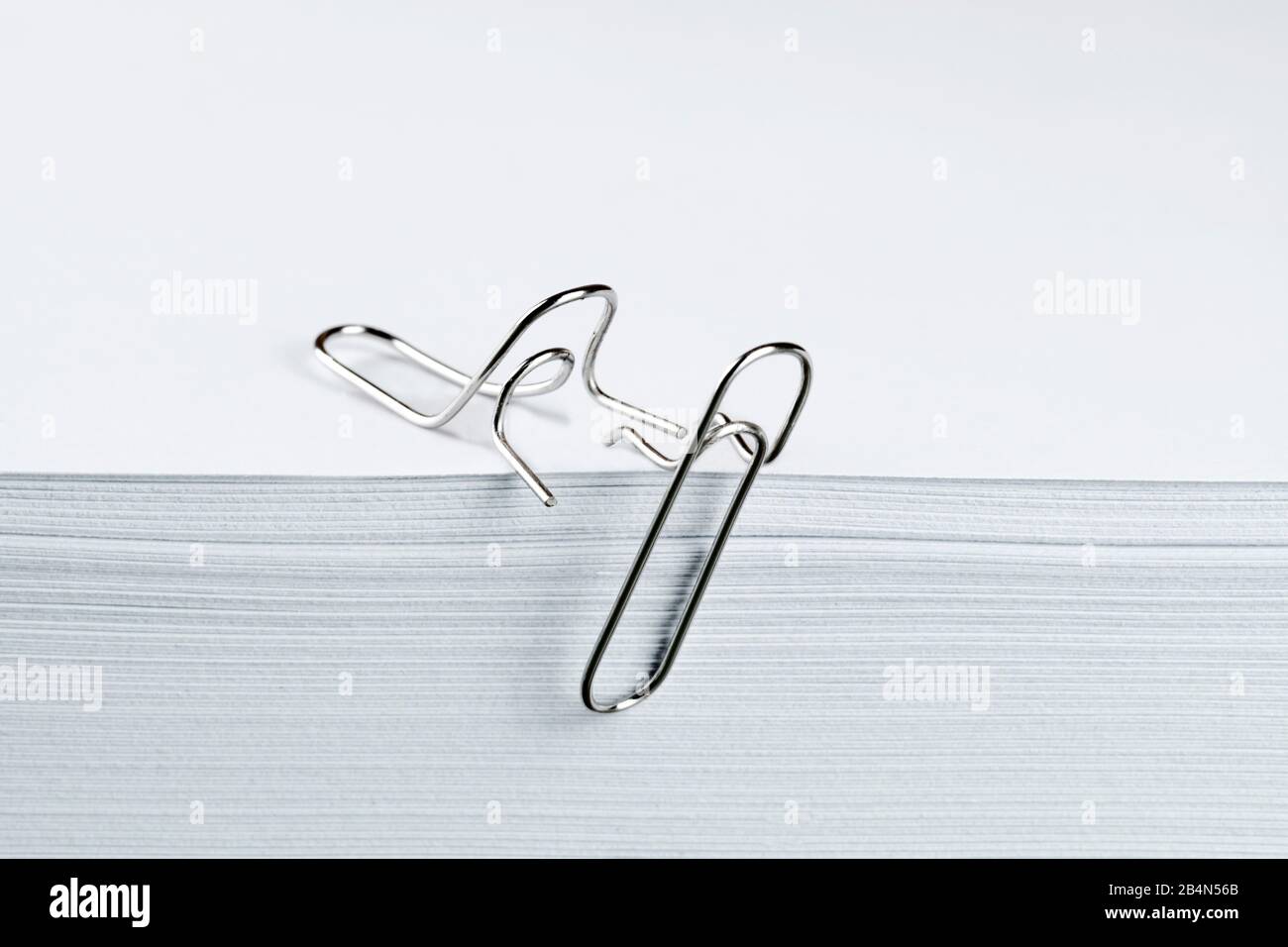Paper clips climb a stack of paper Stock Photo - Alamy