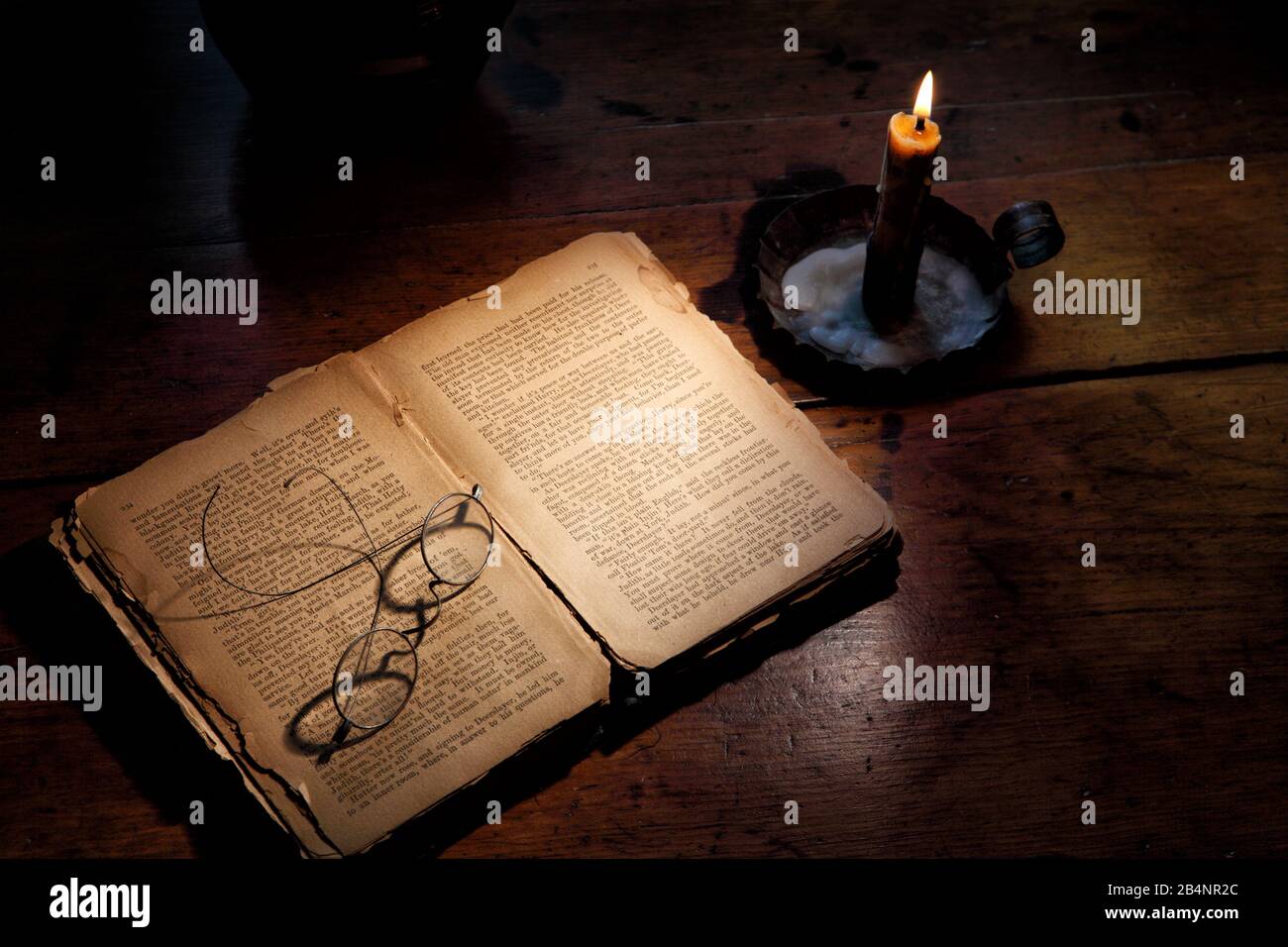 An antique colonial era candle stick illuminating an old delapidated ...