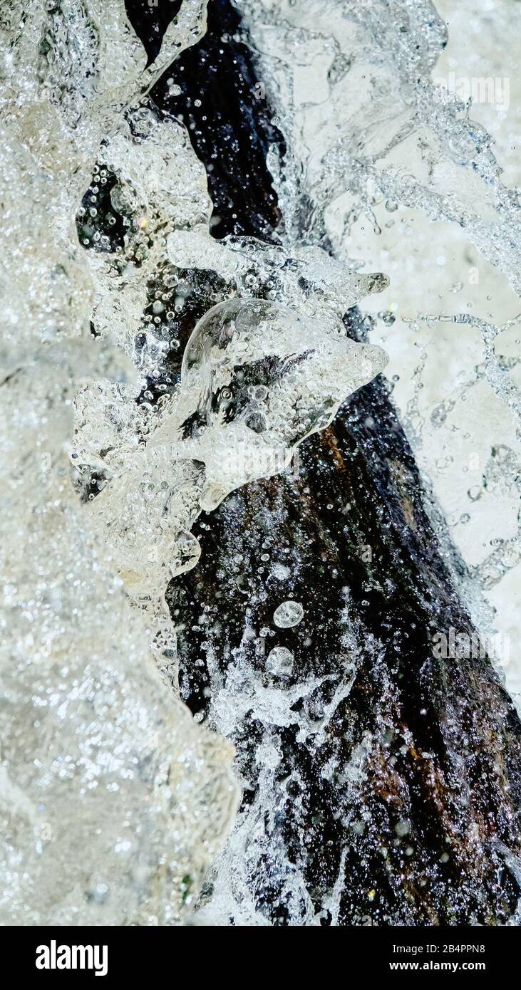 Water backgrounds with foam spray fast flow.The log is stuck in ...