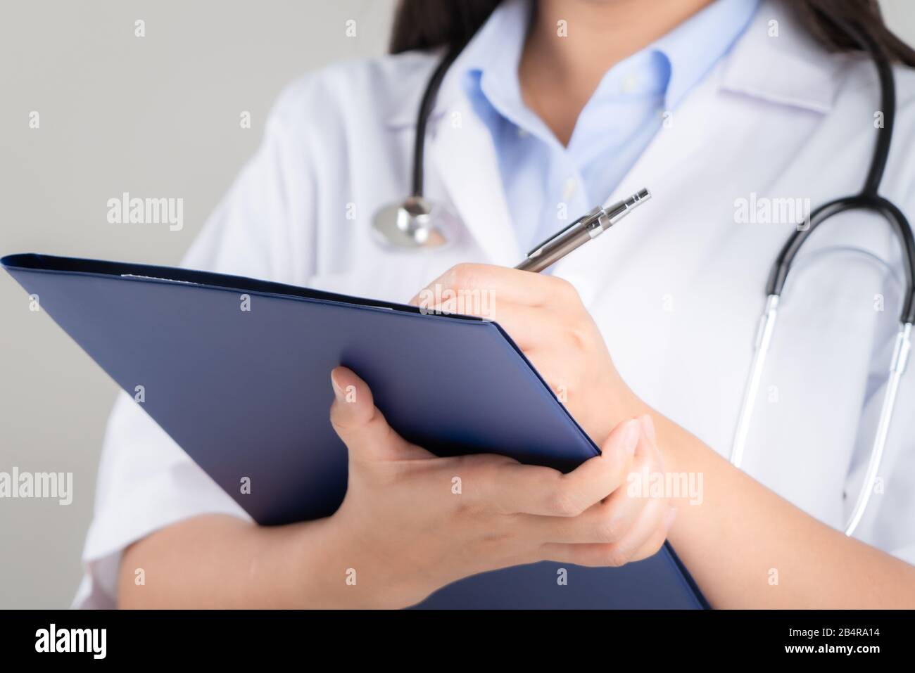 female doctor writing medical information in a notebook at hospital ...