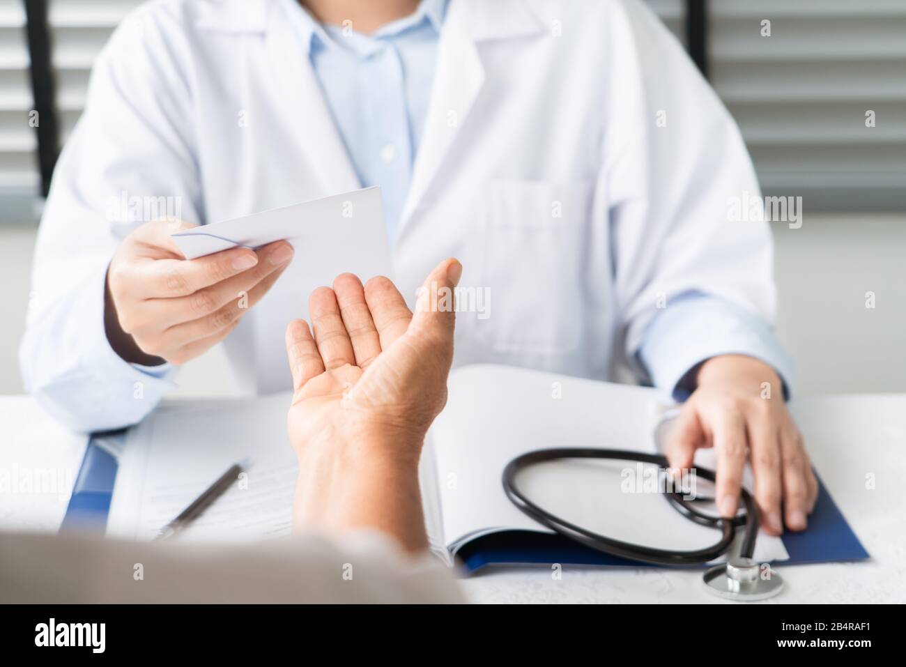 Doctor giving patient documents hi-res stock photography and images - Alamy