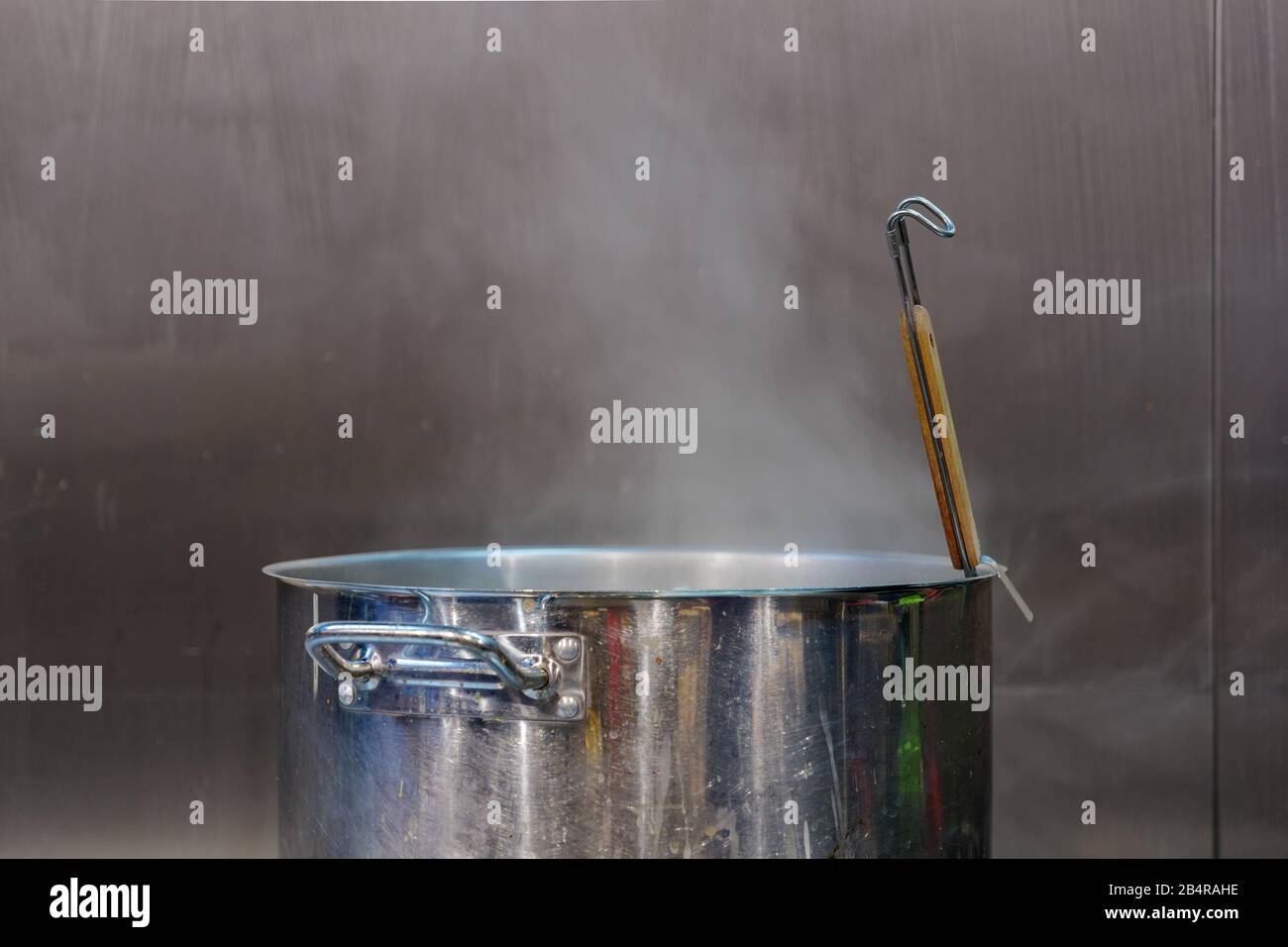 Steam over stainless cooking pot with metallic background over cooking ...